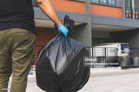 그 청년은 위험한 쓰레기를 커다란 검은 색 가방에 넣고 쓰레기통에 넣었다 폐기물 가정용 폐기물의 올바른 선별 30 34세에 대한 스톡 사진 및 기타 이미지 Istock