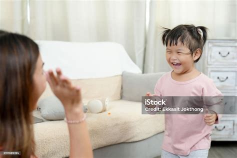 동양인 엄마는 귀여운 딸을 돌보고 학교에 가기 전에 가르칩니다 웃는 유아는 재미있는 학습 활동 후에 기쁨으로 반응합니다 놀이를 통한 정서적 유대감은 행복을 강화합니다 2 3