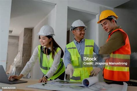 다민족 엔지니어는 주택 및 건물의 설계 건축 및 엔지니어링에 대한 서류 작업 및 평면도 도면에 대한 비용 추정을 위해 브레인스토밍 및 측정합니다 가리키기에 대한 스톡 사진