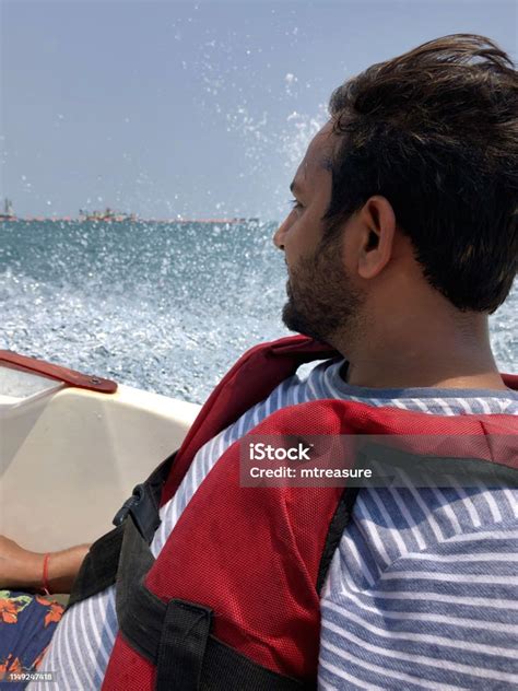 스피드 보트에 인도 남자의 이미지 레드 구명 조끼 부 력 원조를 입고 바다 파도에 의해 튀 었 어 케랄라 해안선코 발 람 해변 남쪽 인도 관광 보트 남자 웃 고 배에 젖 지