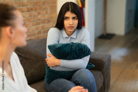 Mother Having Serious Conversation With Her Teen Daughter Sitting