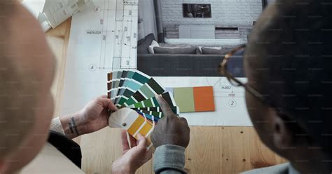 젊은 아프리카 남성 디자이너가 새 프로젝트를 통해 작업하는 동안 여성 동료를 도우면서 색상 팔레트를 가리키고 있다 사진 Unsplash의 사진술 이미지