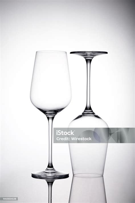 그림자가 있는 흰색 표면에 두 개의 빈 와인잔의 수직 샷 하나는 거꾸로 되어 있습니다 거꾸로에 대한 스톡 사진 및 기타 이미지 거꾸로 유리잔 유리 재료 Istock