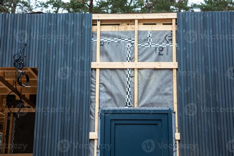 Partially Constructed House With Blue Cladding And Ventilation System
