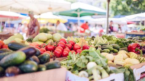 Bustling Outdoor Market Filled With Vendors Selling Fresh Fruits Vegetables And Flowers