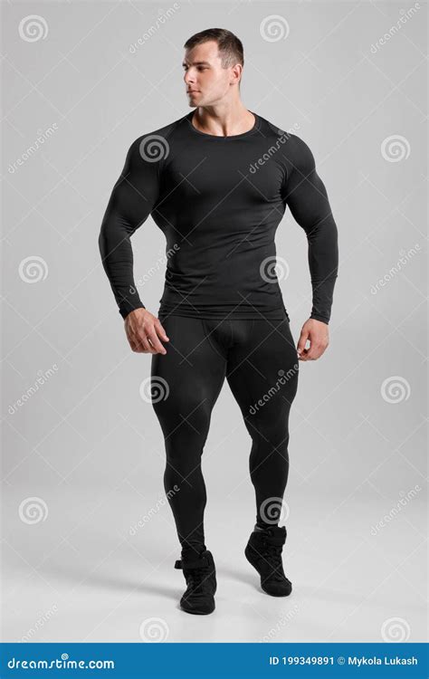 Hombre Musculoso Con Ropa Deportiva De Compresión Negra En Fondo Gris