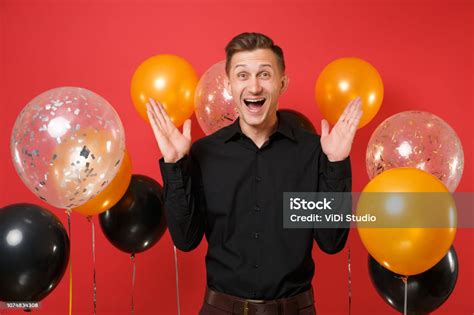 흥분된 젊은 남자 블랙 클래식 셔츠 확산 손에 빨간 배경 공기 풍선에 축 하 세인트 발렌타인 국제 여성의 날 해피 뉴가 어 생일 이랑 휴일 파티 개념 2019년에 대한 스톡