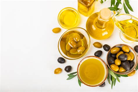 흰색 질감 배경에 병에 담긴 올리브 오일 올리브의 가지와 열매가 달린 기름 병 텍스트를 위한 위치입니다 복사 공간 식용유와