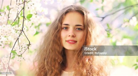 하얀 꽃 배경에 봄 개화 정원에서 긴 곱슬 머리를 가진 아름다운 귀여운 젊은 여성의 초상화 봄에 대한 스톡 사진 및 기타 이미지 봄 벚꽃 아름다움 Istock