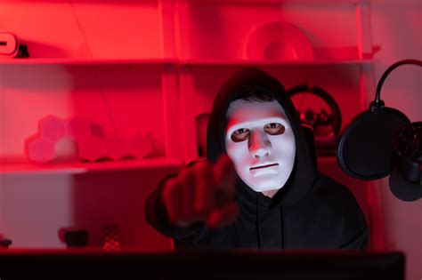 이것은 운영 체제 및 기타 프로그램에 대해 잘 알고있는 해커의 얼굴입니다 그는 결함을 악용하고 컴퓨터 시스템을 침해하여 손상을 입힐 것입니다 검은색에 대한 스톡 사진 및