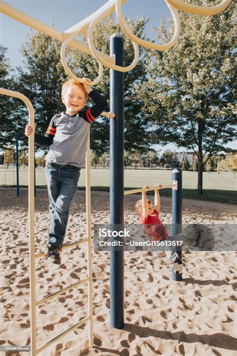 젊은 백인 소년 친구 원숭이 바에 매달려 놀이터에 공원에서 풀 업 바 아이들을위한 여름 야외 활동 활동적인 아이들은 운동을 합니다 건강한 행복한 어린 시절 2명에 대한 스톡