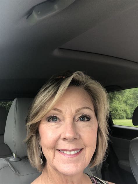 An Older Woman Sitting In The Back Seat Of A Car With Her Eyes Wide Open