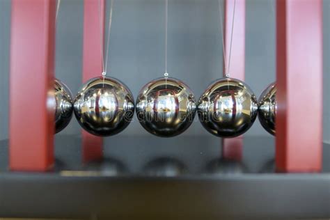 Close Up Of A Newton S Cradle Made Up Of A Row Of Large Copper Balls Stock Photo Image Of Laws