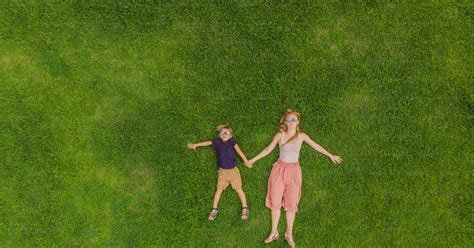 엄마와 아들은 공원의 잔디밭에 누워 있고 드론 쿼드라콥터의 사진입니다 사진 Unsplash의 초상 이미지