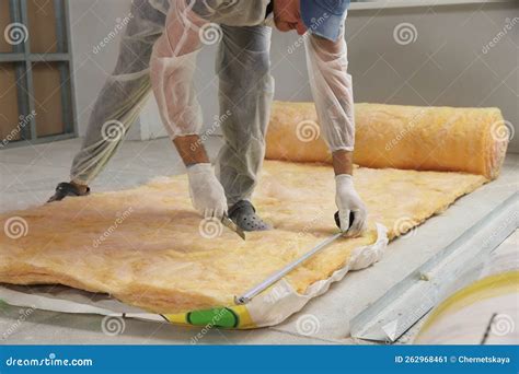 Worker Measuring And Cutting Insulation Material Indoors Stock Image