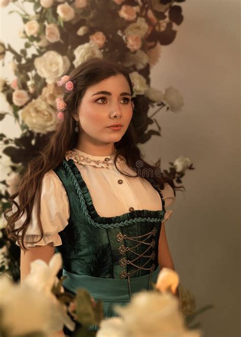 A Young Peasant Woman Standing In A Garden With Flowers Dressed In A 19th Century Bavarian Dress