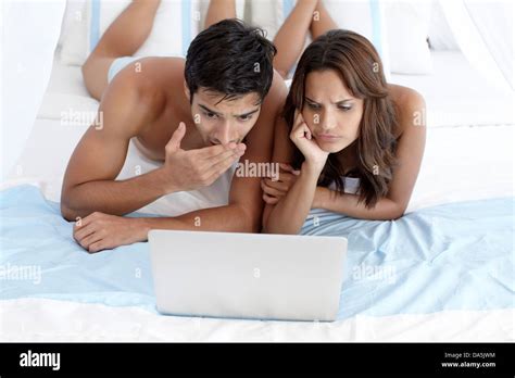 A Couple Using A Laptop Computer On A Bed Stock Photo Alamy