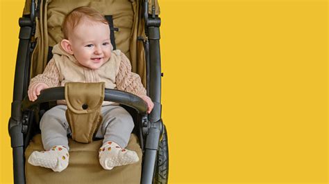 행복한 아이가 스튜디오 노란색 배경에 아기 마차에 앉아있다 어린이 수송을위한 변압기 유모차에 웃는 유아 아기 소년 8 개월 6 11 개월에 대한 스톡 사진 및 기타 이미지