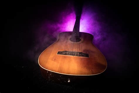 음악 개념입니다 연기와 함께 빛의 광선에서 어두운 배경 음향 기타 문자열 기타 닫습니다 선택적 초점입니다 불 효과 초현실적인 기타 Performing Arts Event에