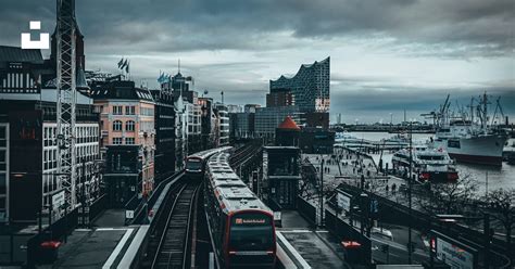 낮에는 도시 건물 근처의 철도 도로에서 빨간색과 검은색 기차 사진 Unsplash의 무료 함부르크 이미지