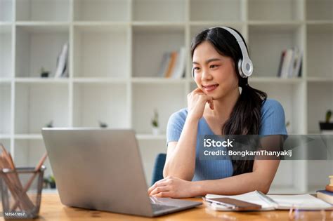 예쁜 아시아 여대생이 헤드폰을 끼고 노트북 화면을 보고 있다 25 29세에 대한 스톡 사진 및 기타 이미지 25 29세 공부 교실 Istock