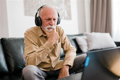 화가 난 노인이 집에서 소파에 앉아있는 동안 노트북으로 화상 통화를합니다 가상 이벤트에 대한 스톡 사진 및 기타 이미지 가상 이벤트 가정 생활 가정의 방 Istock