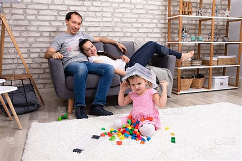 女儿在玩，而父母坐在沙发上