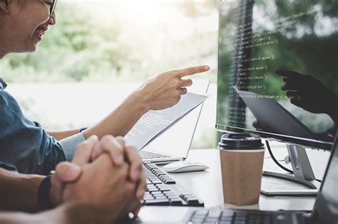 협력 웹 사이트에서 작업 하는 프로그래머는 소프트웨어 개발 회사에서 데스크탑 컴퓨터에 프로젝트 코드를 작성 하 고 입력 데이터 코드 기술 개발에 대한 스톡 사진 및 기타