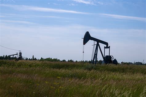 빔 펌핑 유닛은 숙제 오일 필드의 일몰입니다 석유 펌프 오일 장비 에너지 산업 기계 펌프가 우물에 설치 된 펌핑 장치 오일 분야의 장비 가솔린에 대한 스톡 사진 및 기타