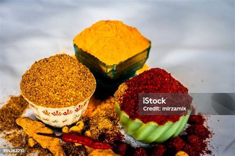 춧 가루 심 황 가루와 말린 고 수 씨앗 가루 원시 향신료와 함께 흰색 절연 인도 아시아 식품의 세 가지 기본 향신료의 닫습니다 갈색에 대한 스톡 사진 및 기타 이미지