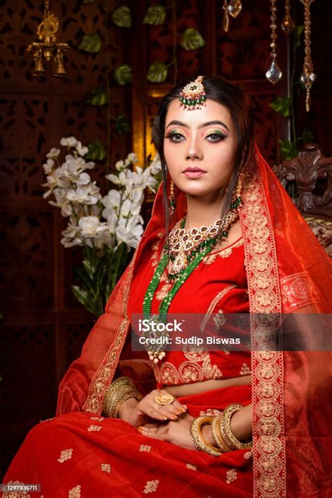고급스러운 드레스와 귀중한 보석을 입은 웅장한 젊은 인도 신부가 고급 아파트의 의자에 앉아 있습니다 클래식 빈티지 인테리어 웨딩 패션 신부에 대한 스톡 사진 및 기타 이미지