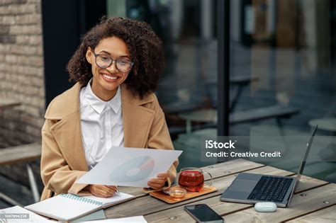 카페 테라스에 앉아 원격으로 일하는 아프리카계 미국인 여성 프리랜서 25 29세에 대한 스톡 사진 및 기타 이미지 25 29세 거리가 먼 경영자 Istock