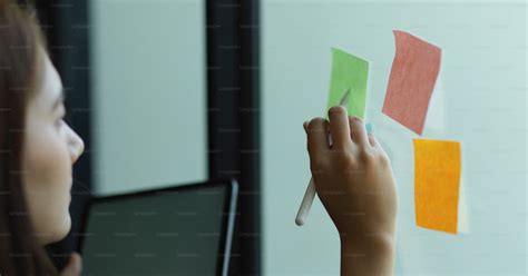 디지털 태블릿으로 작업하는 여성 직장인의 자른 사진과 사무실에서 아이디어가 담긴 스티커 메모 사진 Unsplash의 그것의