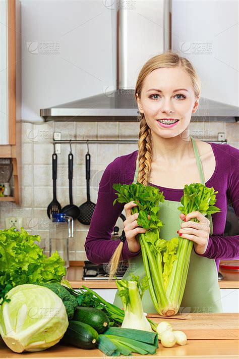 厨房里的女人在吃绿色蔬菜