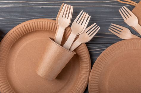 친환경 일회용 종이 식기 종이컵 종이 봉지 나무 포크 나무 배경에 종이 접시 재활용 또는 녹색 개념 복사 공간 소풍 음식에 대한