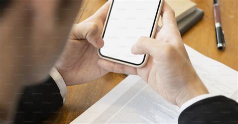 사무실 책상에 앉아 스마트폰을 사용하는 사업가의 어깨 너머로 볼 수 있다 사진 Unsplash의 테이블 이미지