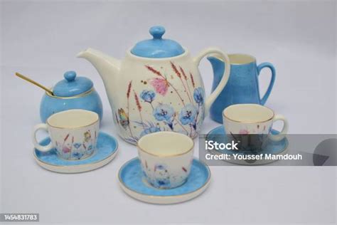 우아하고 전통적인 도자기 파란색과 흰색의 우아한 꽃 도자기 중국 세라믹 차 커피 컵과 찻주전자 및 접시 세트의 모형 디자인 세트와 흰색 배경에 격리된 금숟가락 음료 용기 0