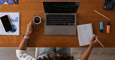 노트북과 커피 한 잔을 들고 책상에 앉아 있는 사람 사진 Unsplash의 사업 자금 이미지