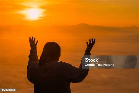 기도하는 여자의 실루엣은 아침에 일출 하늘을 배경으로 하나님을 경배한다 손바닥을 위로 하여 예배를 드리는 사람 회개를 도우시는 하나님 가톨릭 부활절 마음 빌려주기기도 기독교