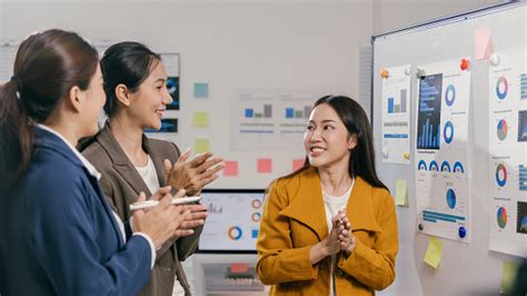 세 명의 아시아 여성 사업가가 사무실 회의실에서 성공적인 프레젠테이션을 마친 후 박수를 치며 동료를 축하하고 있습니다 20 29세에 대한 스톡 사진 및 기타 이미지 Istock