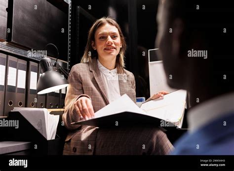Woman Police Officer Explaining Criminal Case To African American Detective Working At Federal