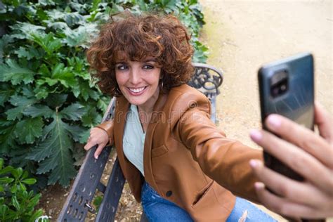 Beautiful And Woman With Curly Hair Is Taking Pictures Of Herself With