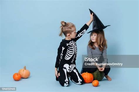 해골 의상을 입은 소년이 여자아이의 마녀 모자를 벗고 그를 쳐다보고 있다 10월에 대한 스톡 사진 및 기타 이미지 10월