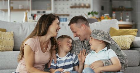 가족과 함께 바닥에 앉아 있는 행복한 군인 군인과 그의 아내는 아이들과 함께 집에서 즐기고 있습니다 사진 Unsplash