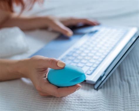 A Woman Lies In Bed Holding A Clitoral Vibrator And Watching On A Laptop The Girl Has Sex