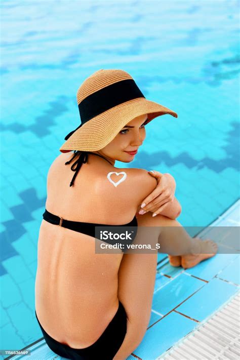 무두질 어깨에 선 크림 크림을 적용 하는 여자 선 보호선 크림 스킨 과 바디 케어 그녀의 피부에 자외선 차단제를 사용하여 소녀 선탄 로션과 보습 선블록을 들고 있는 여성의