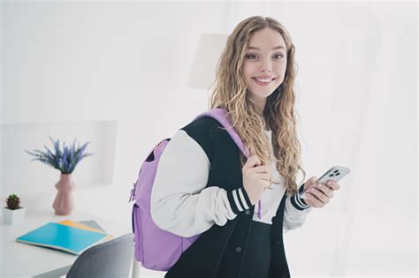 사진 달콤한 예쁜 십대 소녀 홀드 가제트 배낭 착용 세련된 교복 아침 루틴 화이트 인테리어 침실 아파트 Brand Name Smart Phone에 대한 스톡 사진 및 기타