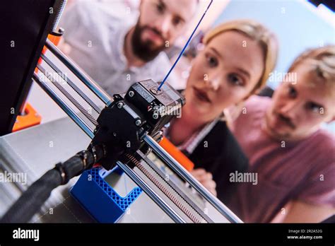 A Group Of Colleagues Working Together In A Robotics Laboratory Focusing On The Intricate