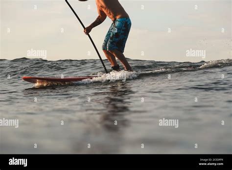 Crop Bottom Of Male Surfing Between Water Of Sea On Bali Indonesia Stock Photo Alamy