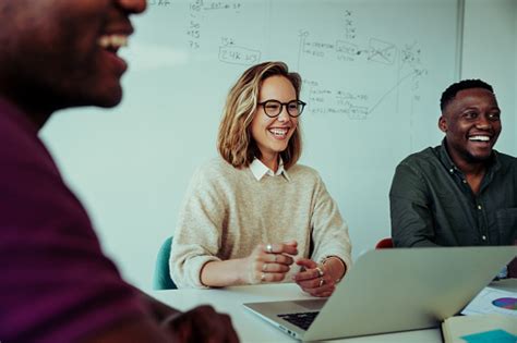 컨퍼런스 미팅 에서 테이블 주위에 앉아있는 동료가 제시 한 새로운 프로젝트에 대한 아이디어를 웃고있는 여성 비즈니스 여성 가리키기에 대한 스톡 사진 및 기타 이미지 Istock
